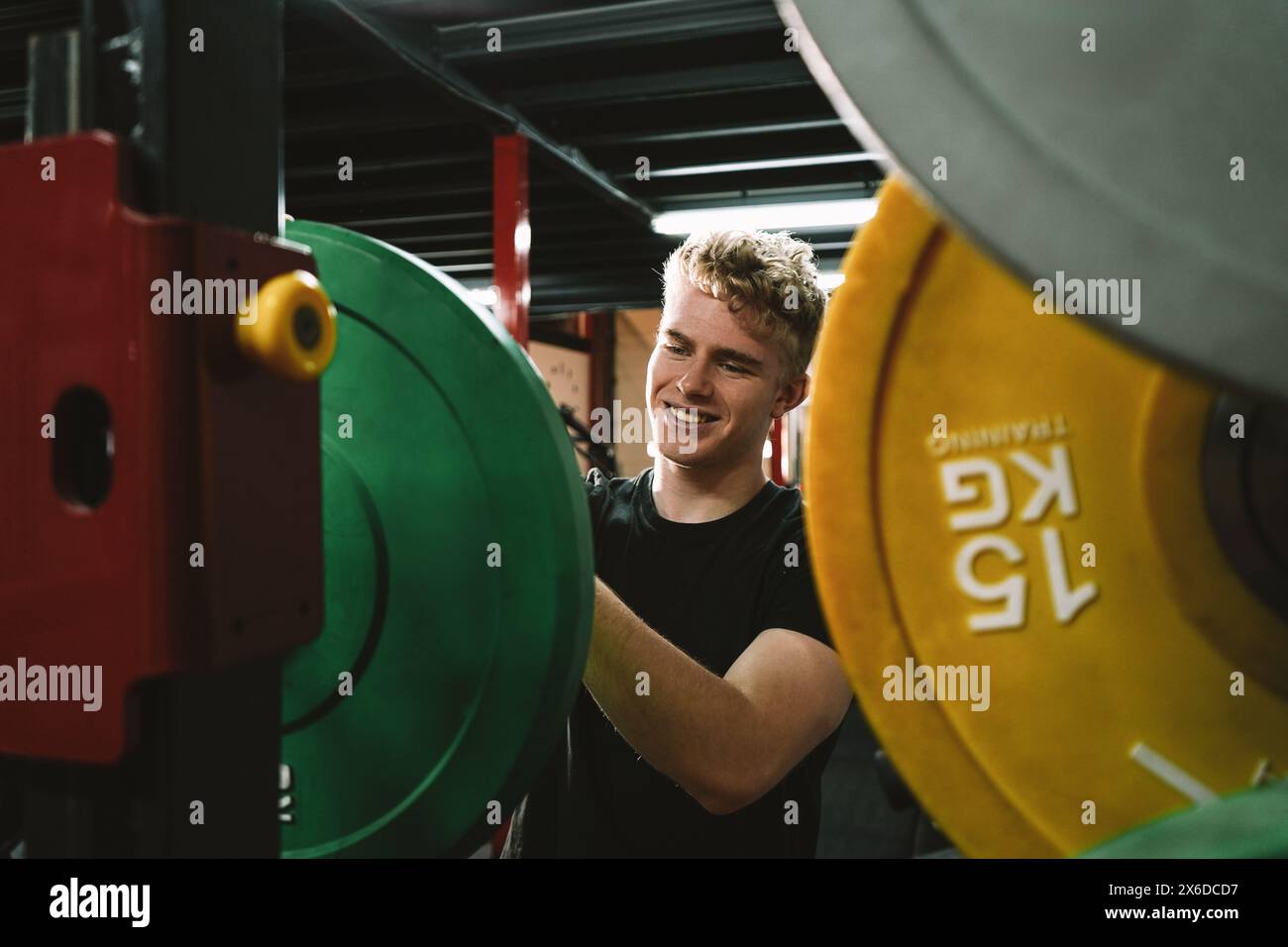 Handsome happy male crossfit athlete putting weights on a barbell Stock ...