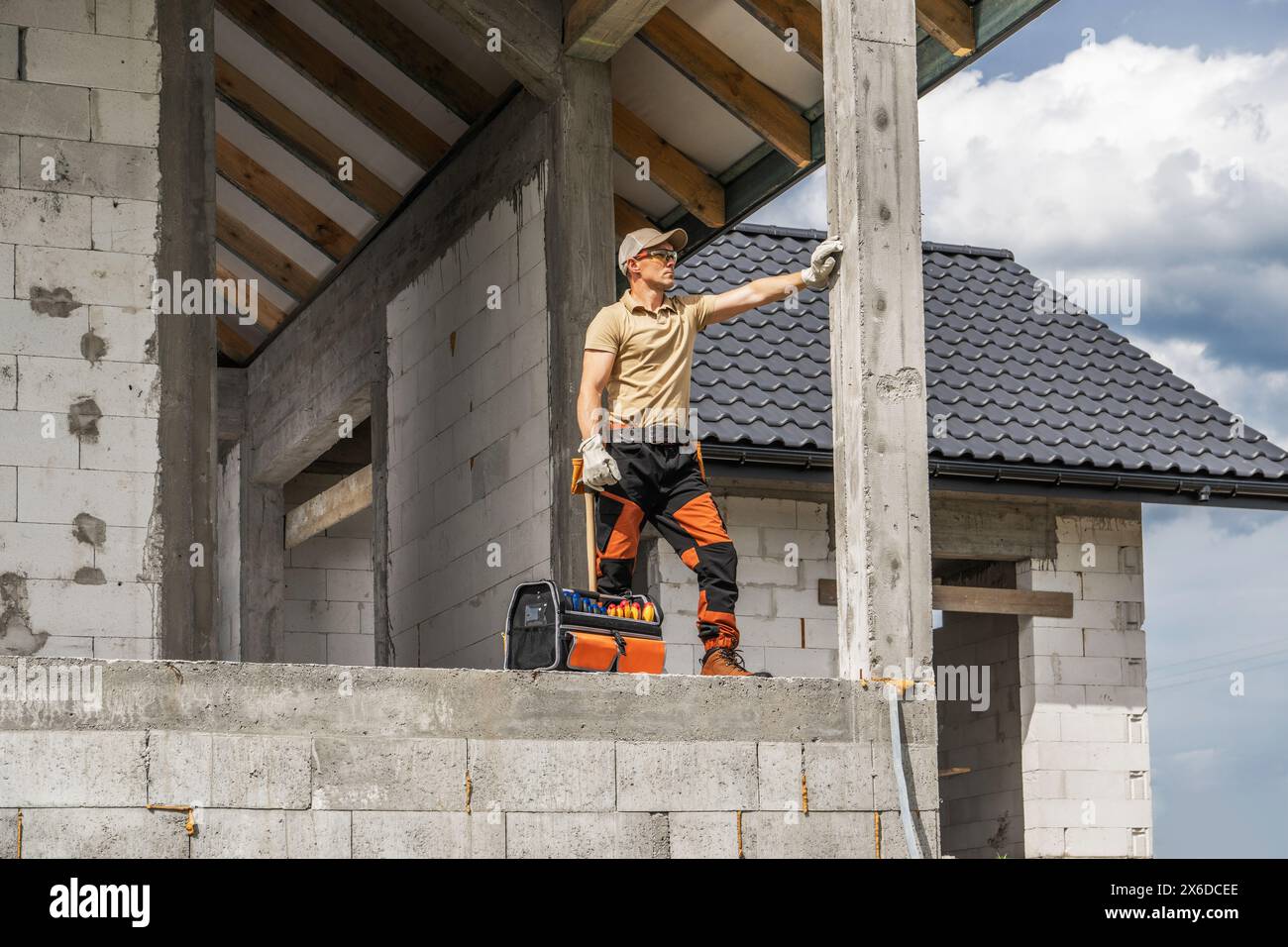 Professional construction worker standing on house side Stock Photo - Alamy