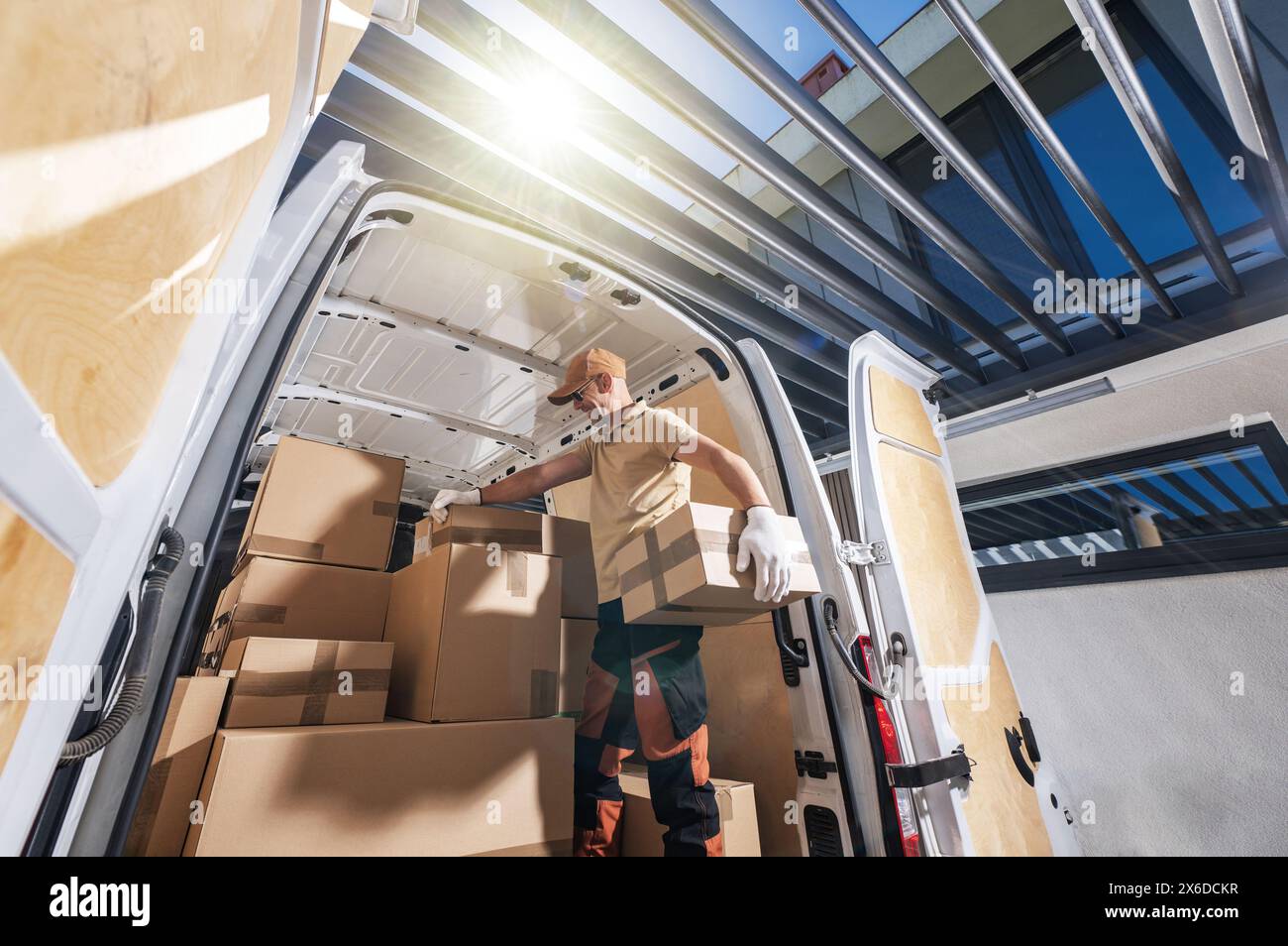 Courier lifting and placing boxes into a van for transport. Parcel ...