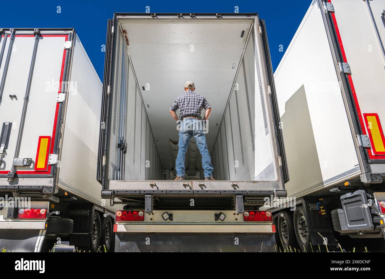 Frustrated caucasian commercial driver standing inside of an empty semi ...