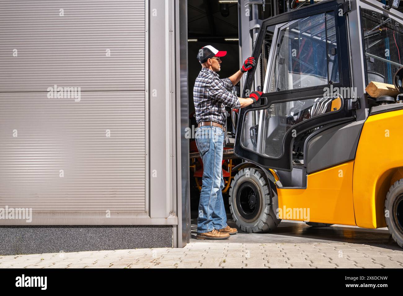 Caucasian forklift driver in his 40s maneuvering fork truck into ...