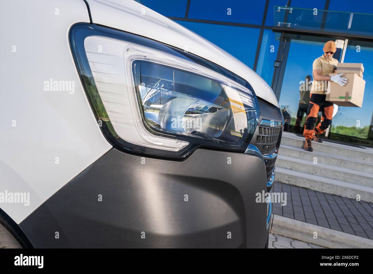 Courier picking up parcel from a client. White cargo van in the first ...