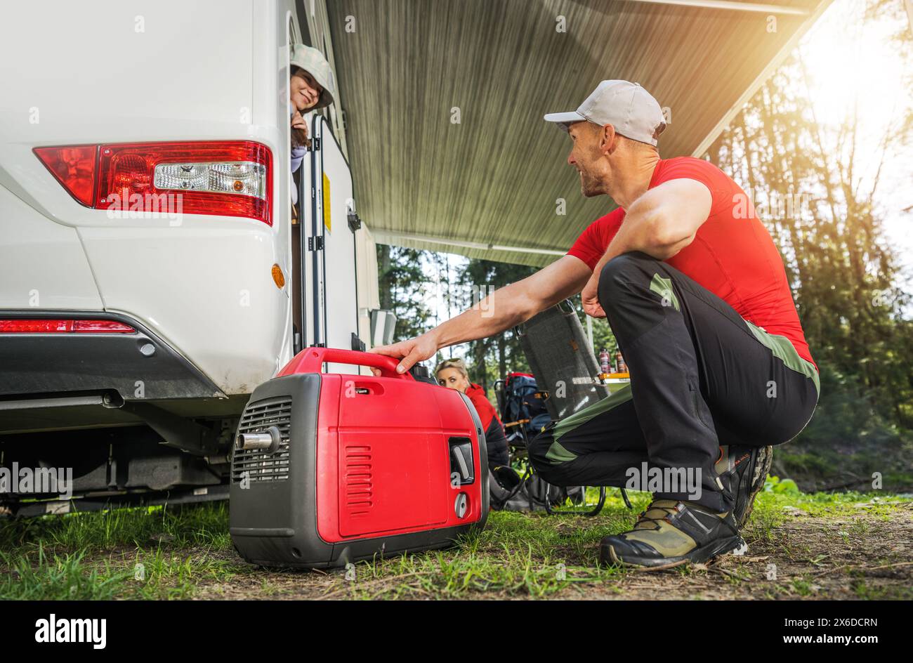 Man starting a generator in front of his RV while camping Stock Photo ...