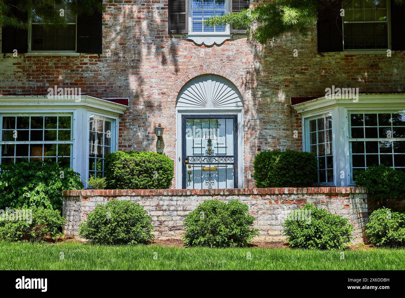 Traditional Brick House with Ornate Doorway and Lush Garden, Suburban ...