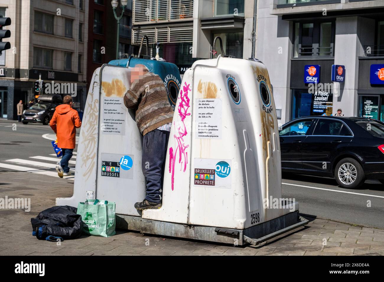 Man picking and collecting returnable bottle out of a glass recycling ...