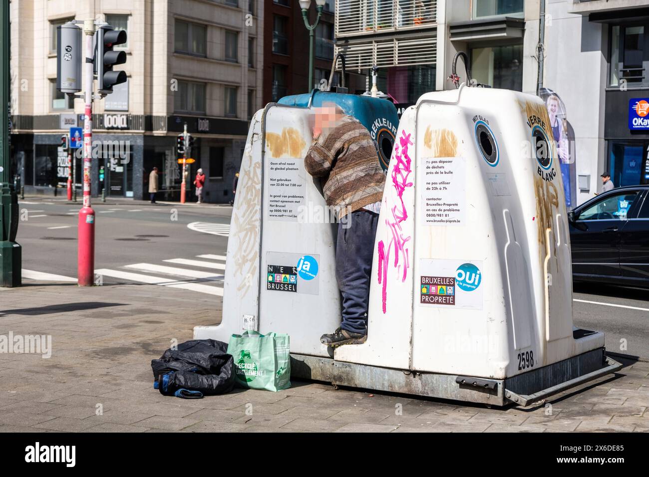 Man picking and collecting returnable bottle out of a glass recycling ...