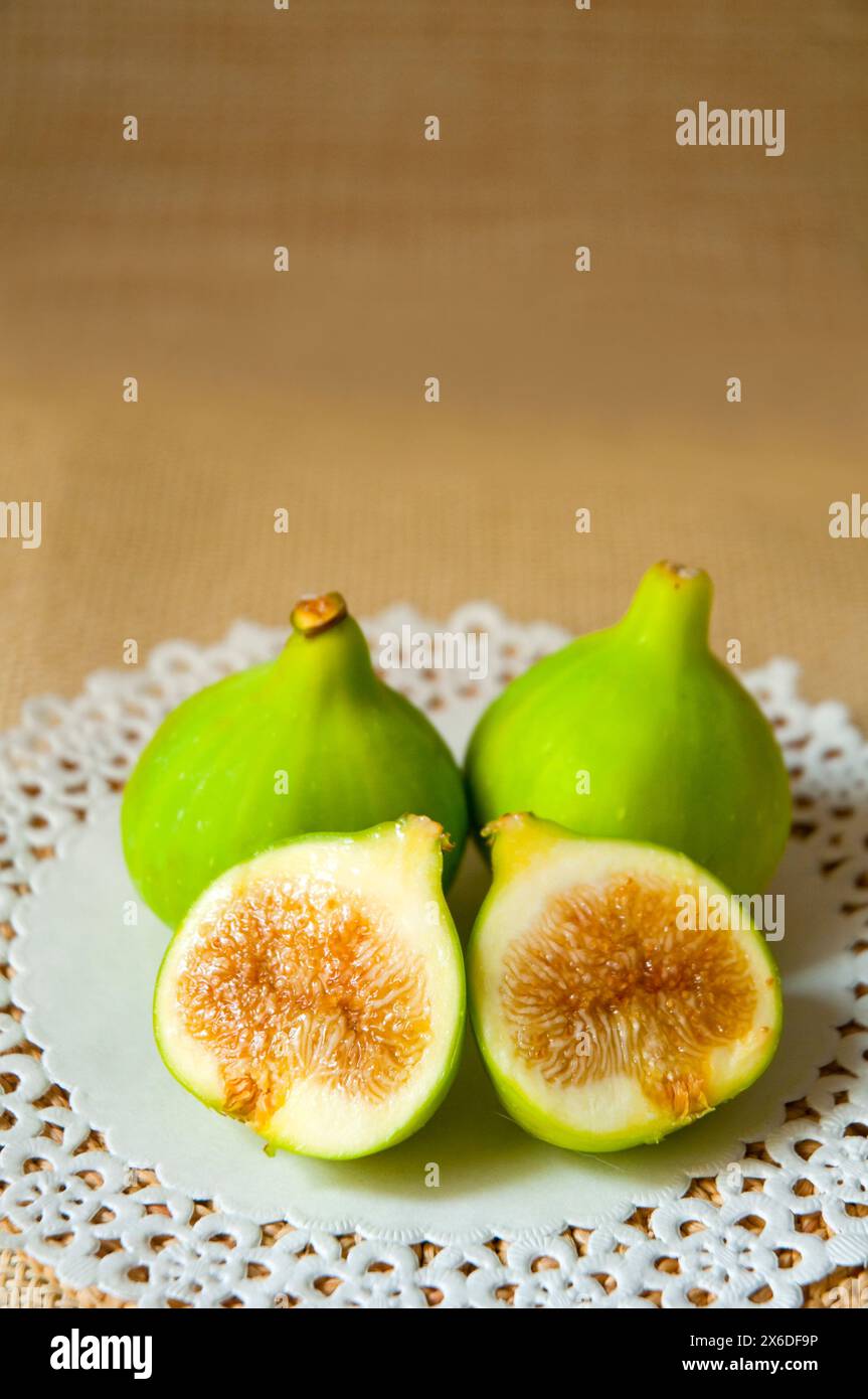 Three figs, one of them cut in two halves. Still life Stock Photo - Alamy