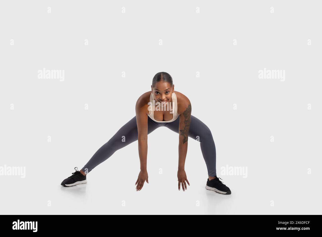 African American Woman Performing a Squat on White Background Stock ...