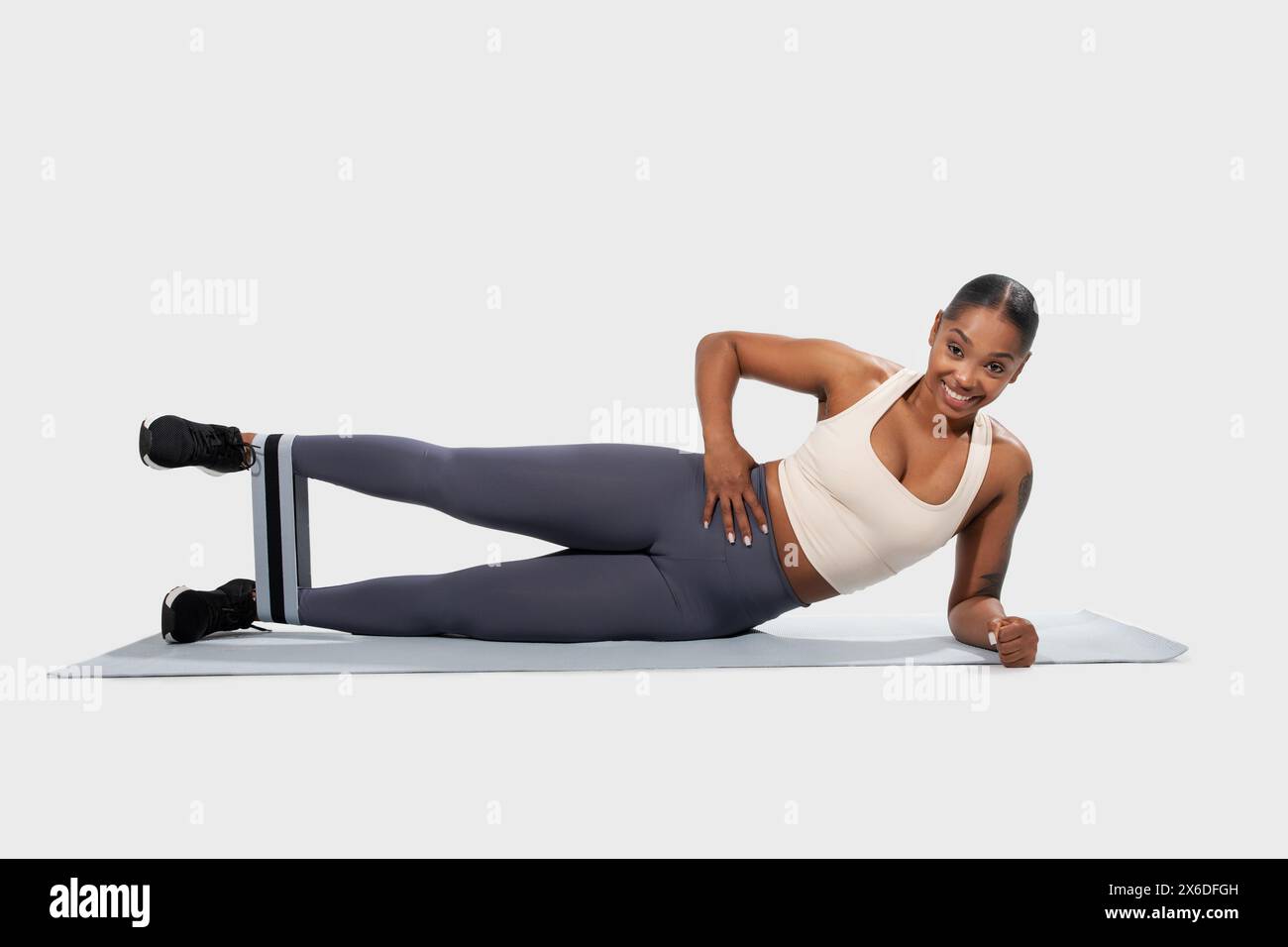 Smiling Woman Performing Side Plank Exercise With Resistance Band Stock ...