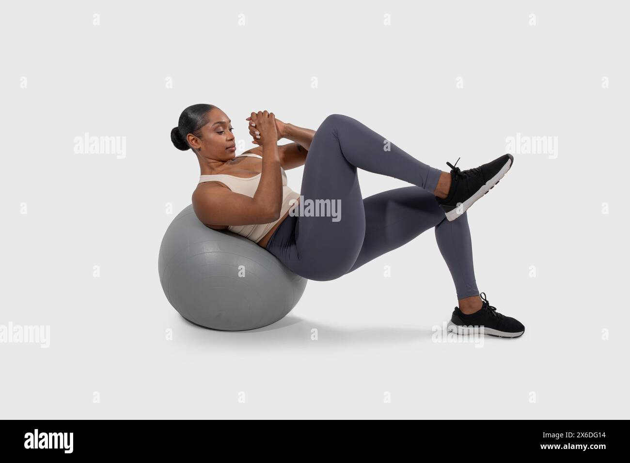 Young Woman Performing Core Strengthening Exercises on a Fitness Ball ...