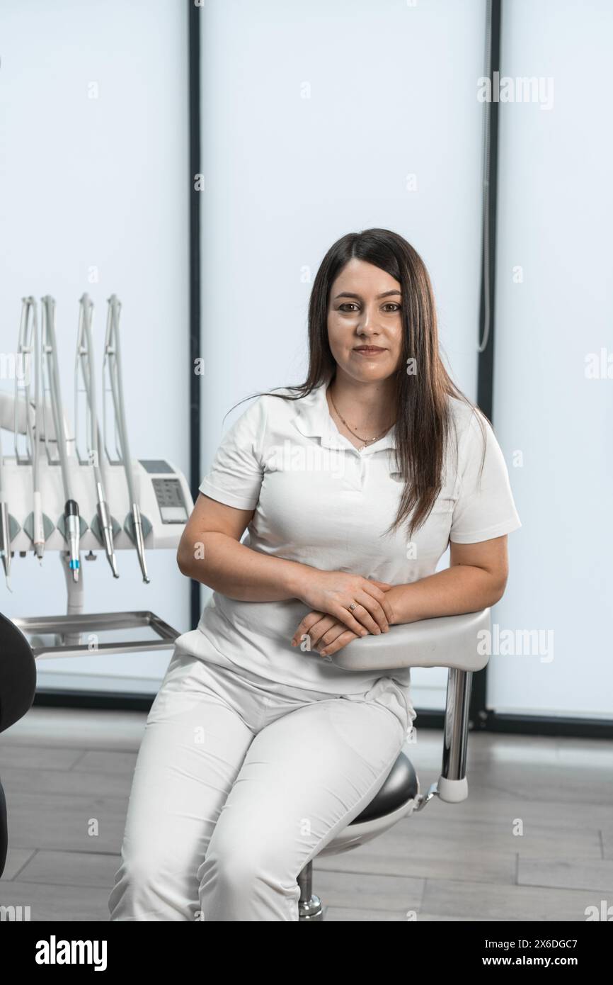 With an expression of care and aesthetics, the dentist demonstrates her ...