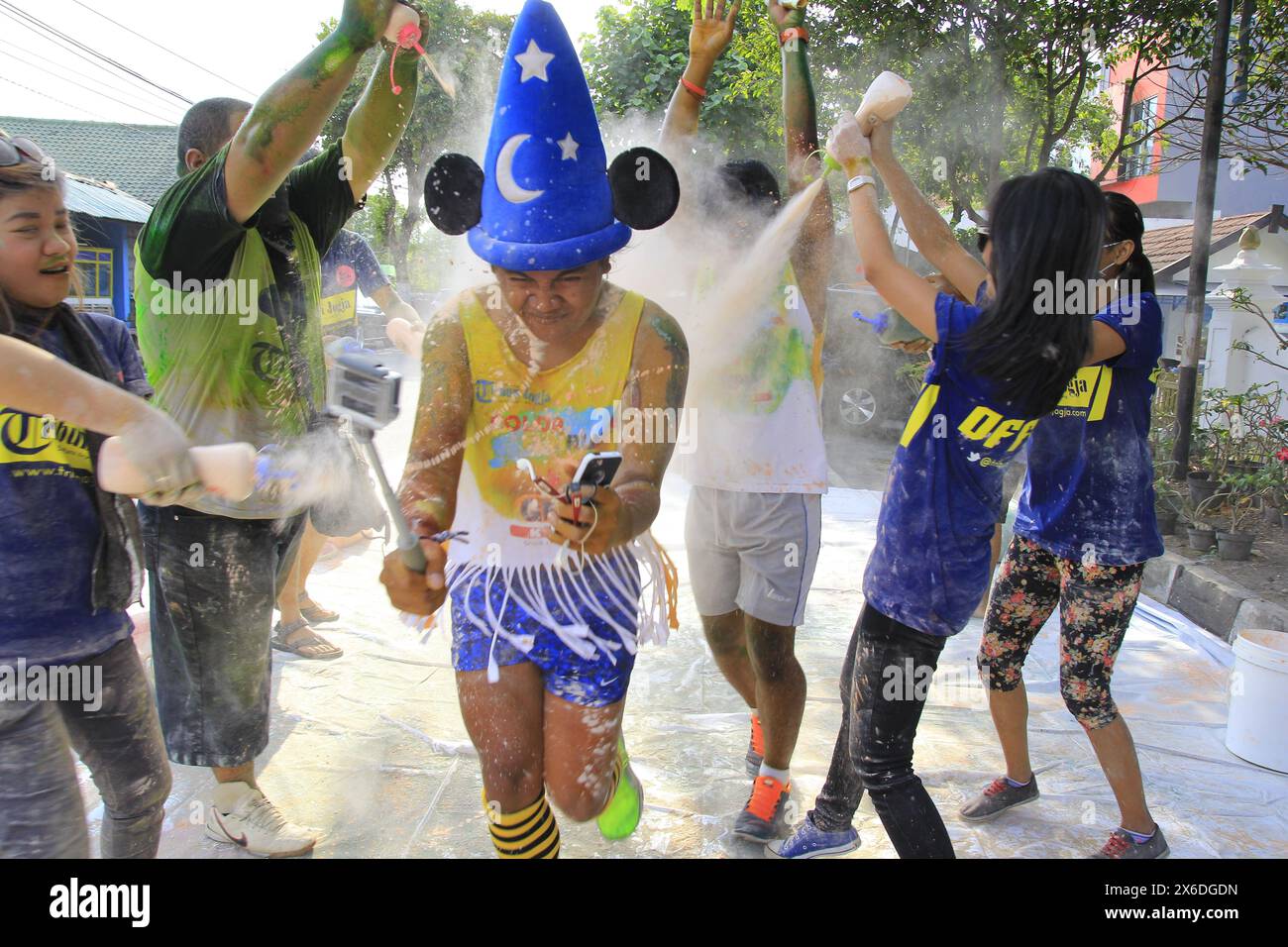 A group of young people sprinkling color powder with excitement to ...