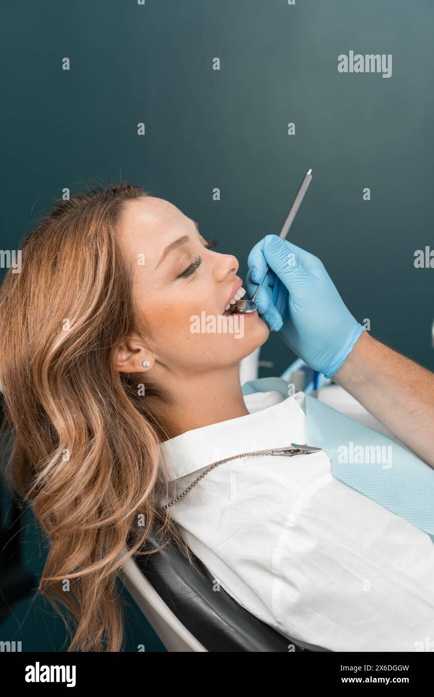 The doctor pretends to examine the condition of the teeth with a ...