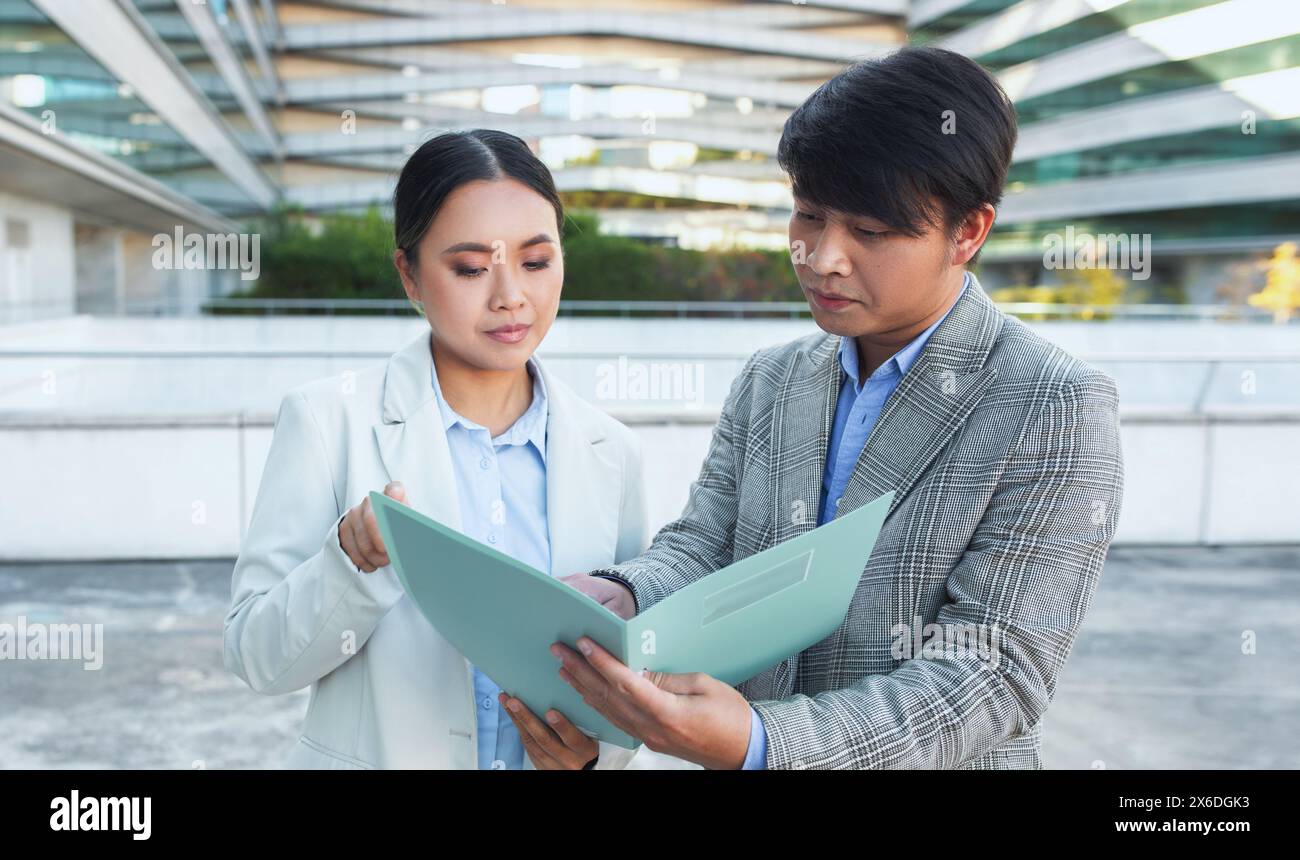 Two Business People Reviewing Folder Outside Office Building Stock ...