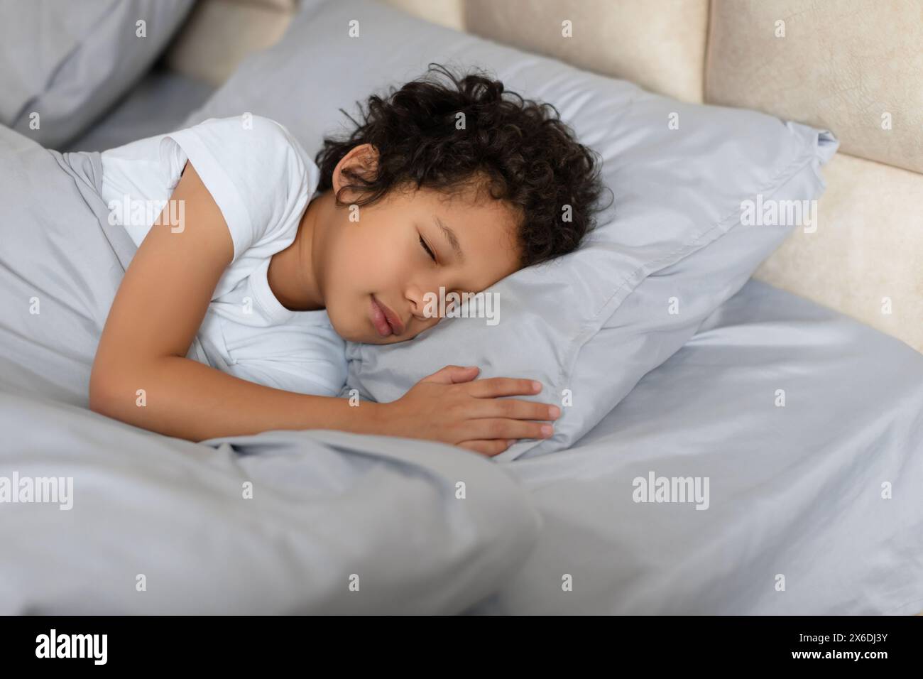 Young Child Sleeping Comfortably in Bed With Pillow Stock Photo - Alamy