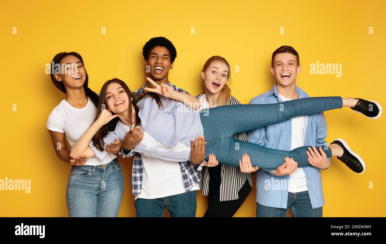 Group of Teenagers Posing for Picture, Holding Their Friend Stock Photo ...