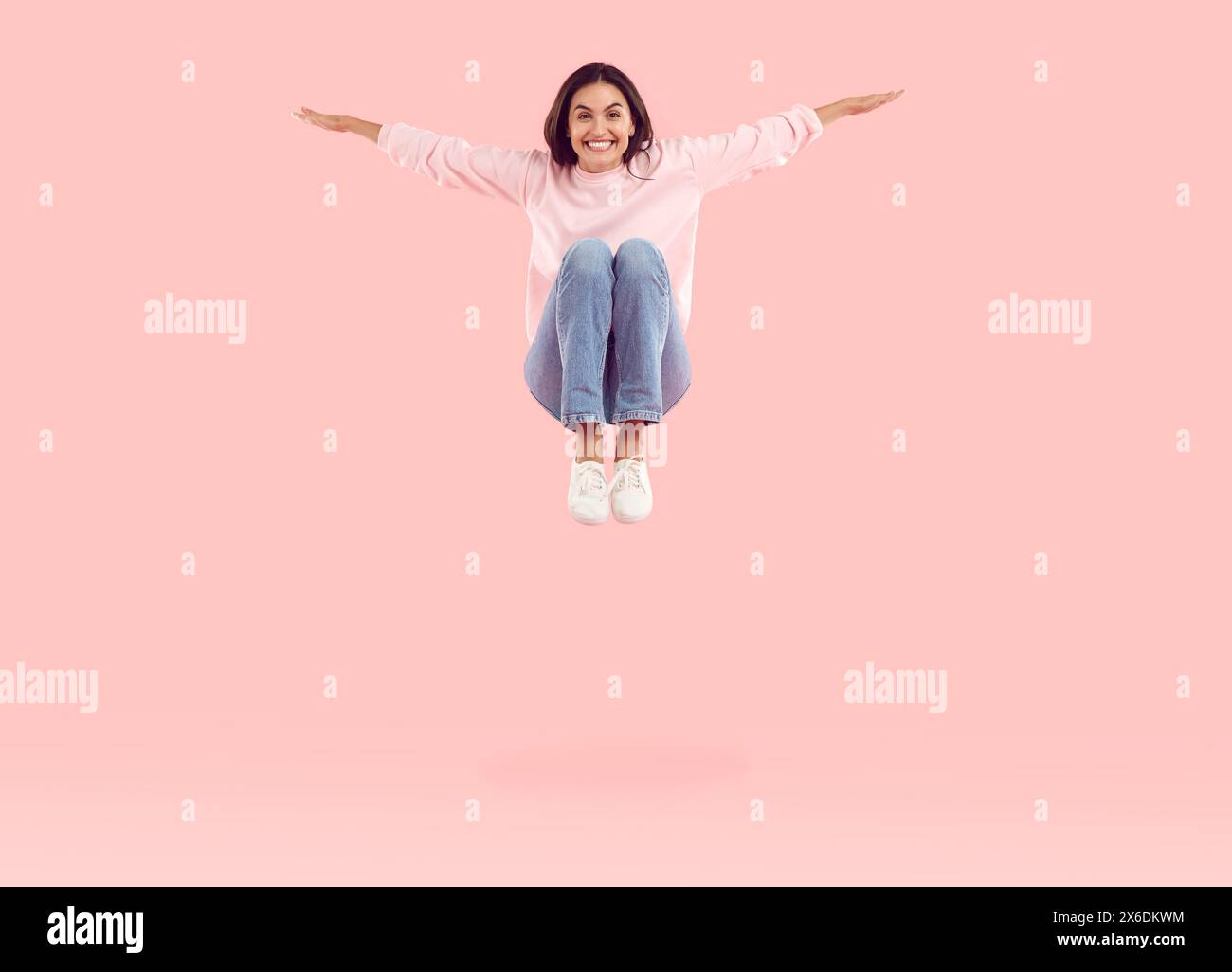 Happy cheerful excited young woman jumping up on trampoline and flying ...
