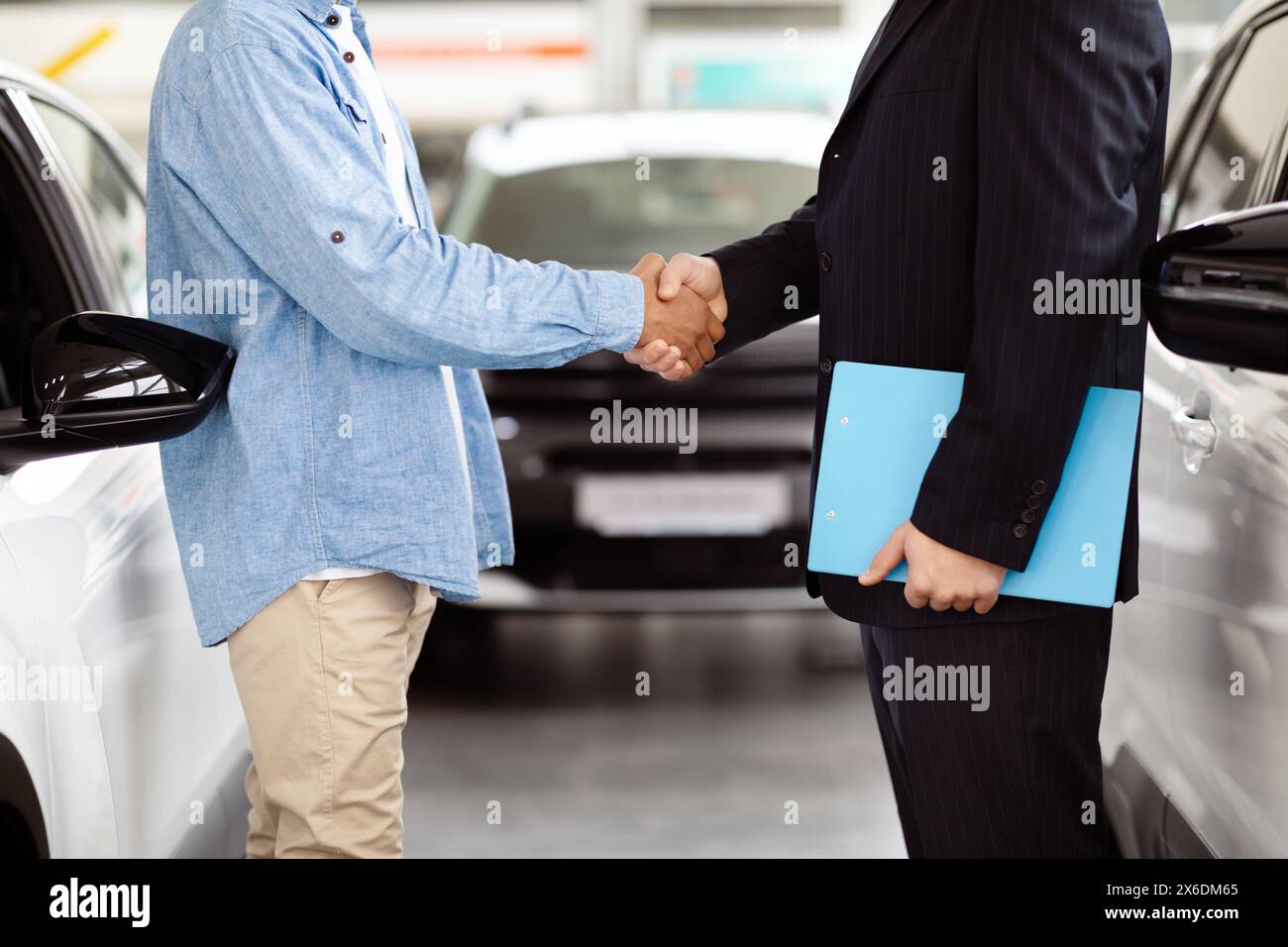 Two People Shaking Hands in Front of a Car Stock Photo - Alamy