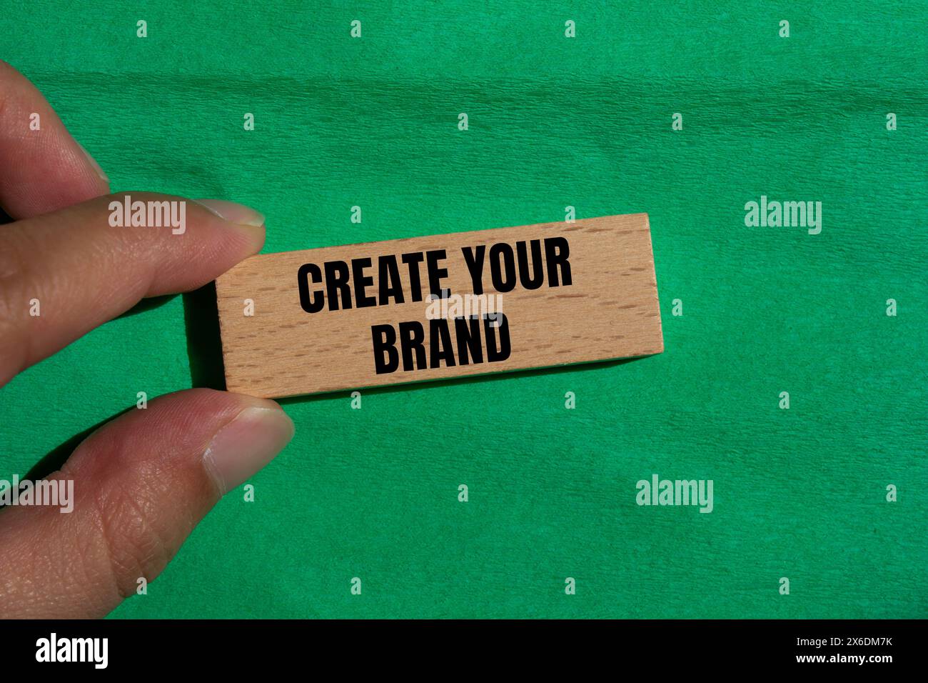 Create your brand words written on wooden blocks with green background ...