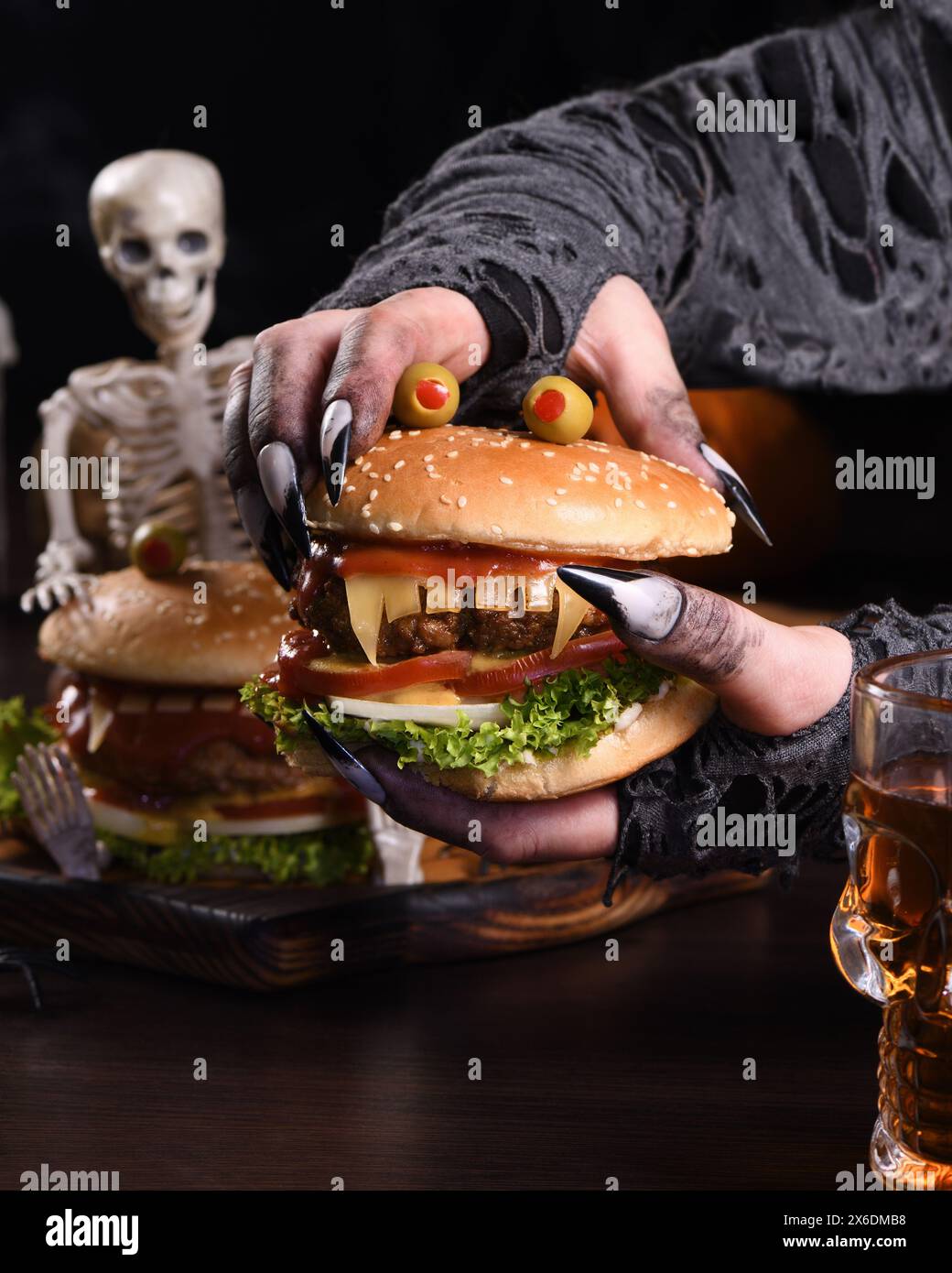 The witches hands hold a Monster Burger in her palms on a sitting ...