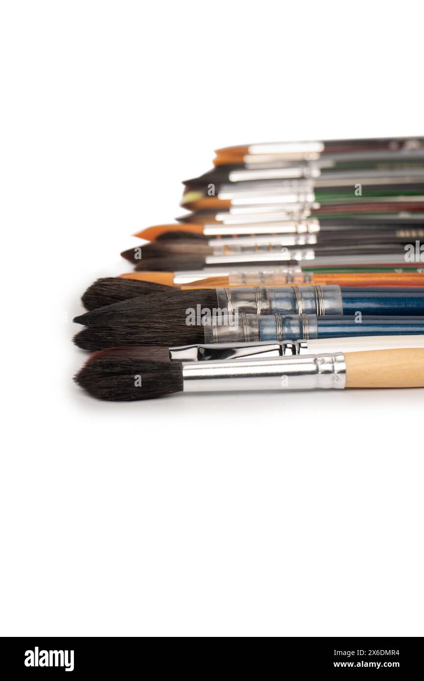 Mix of paint brushes in a row isolated on a white background. Top view ...