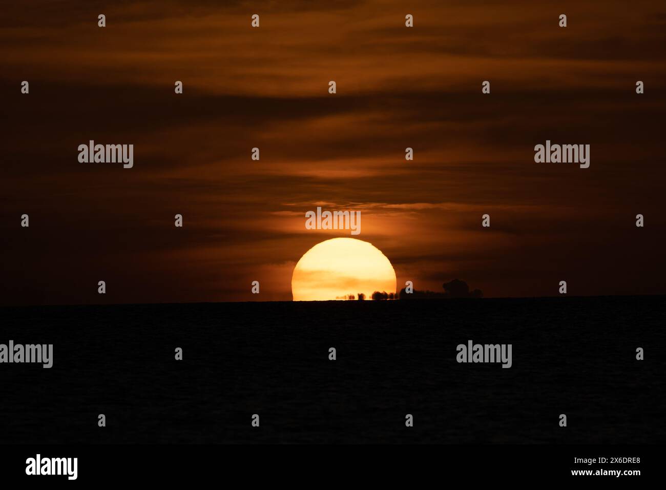 A mesmerizing close-up of the sun setting over the horizon in ...