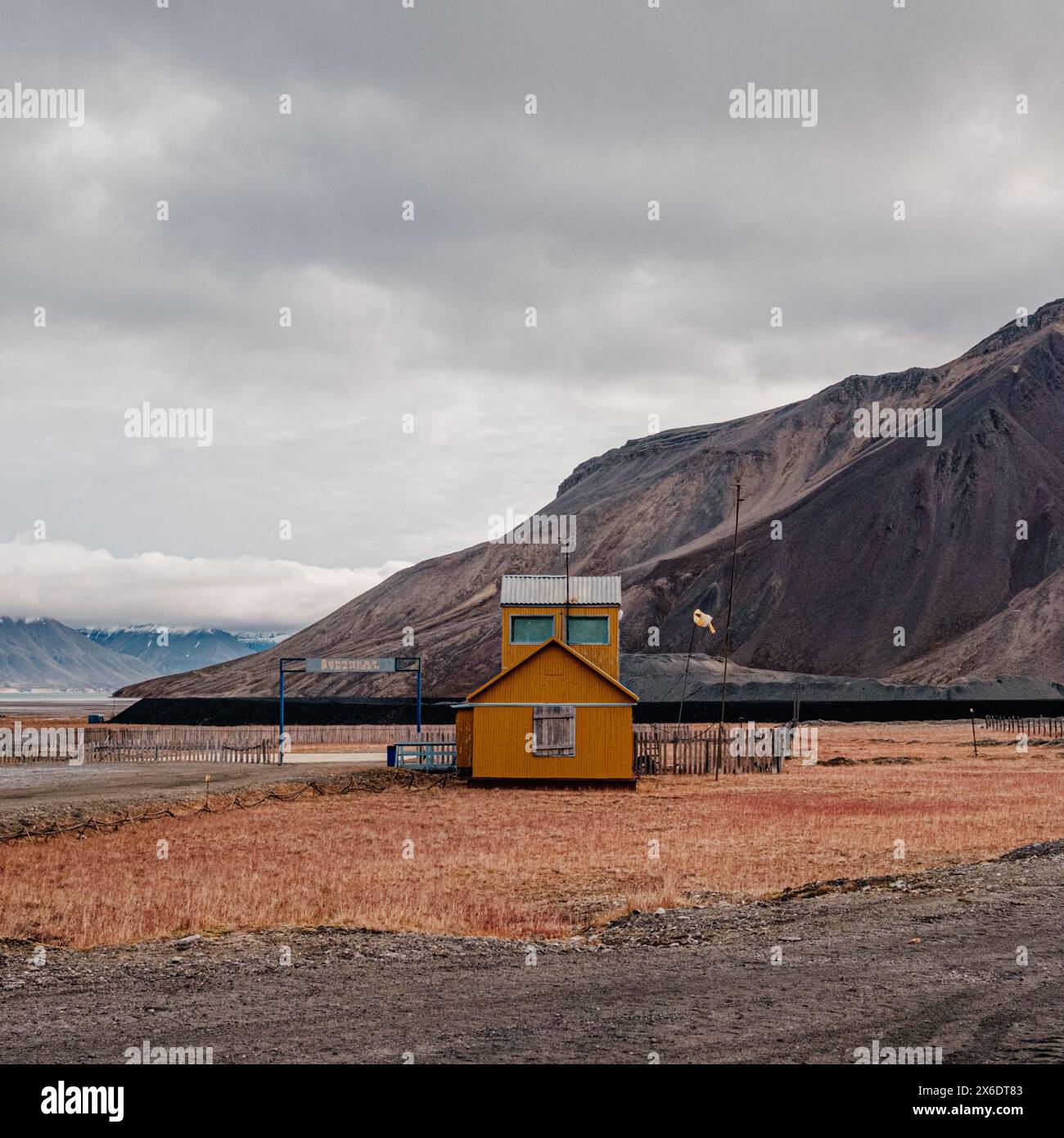 Colorful yellow building in the desolate landscape of Pyramiden ...