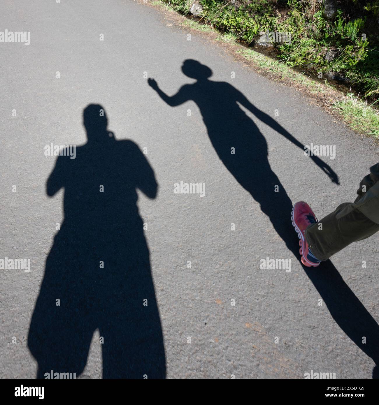 Shadows of a man and a woman along the hike to Risco Waterfall trail ...