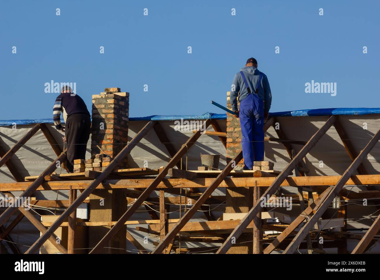 Villagers working together to build a house rooftop Stock Photo - Alamy