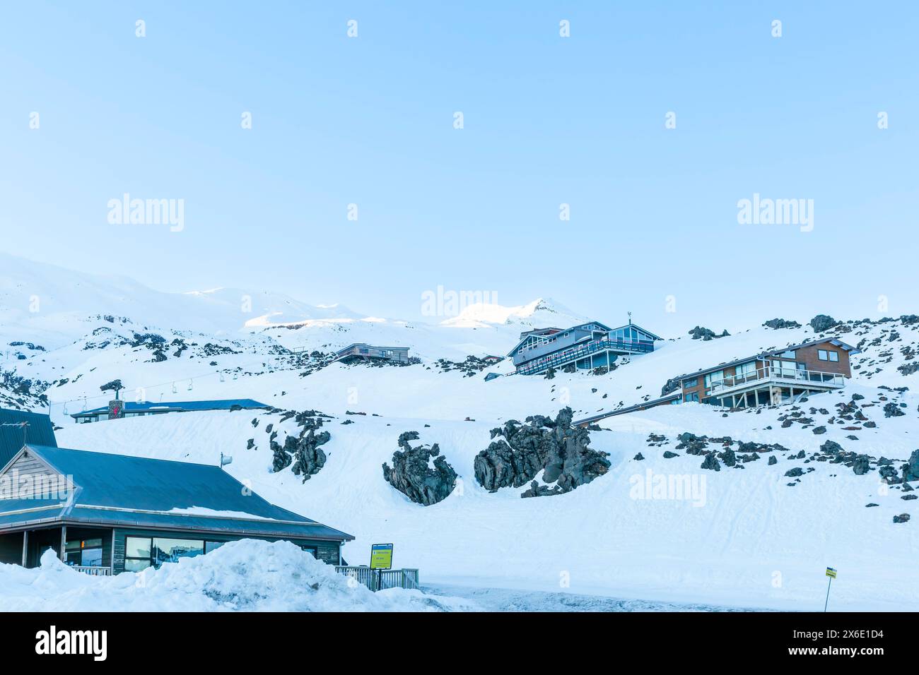 Whakapapa ski-field with lodge buildings on shady side of mountain as ...