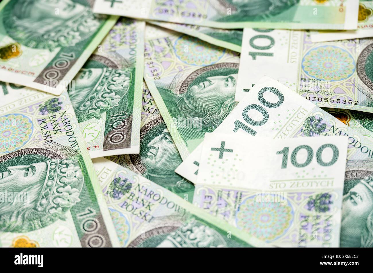 A close-up view of scattered Polish 100 Zloty banknotes spread out. The ...