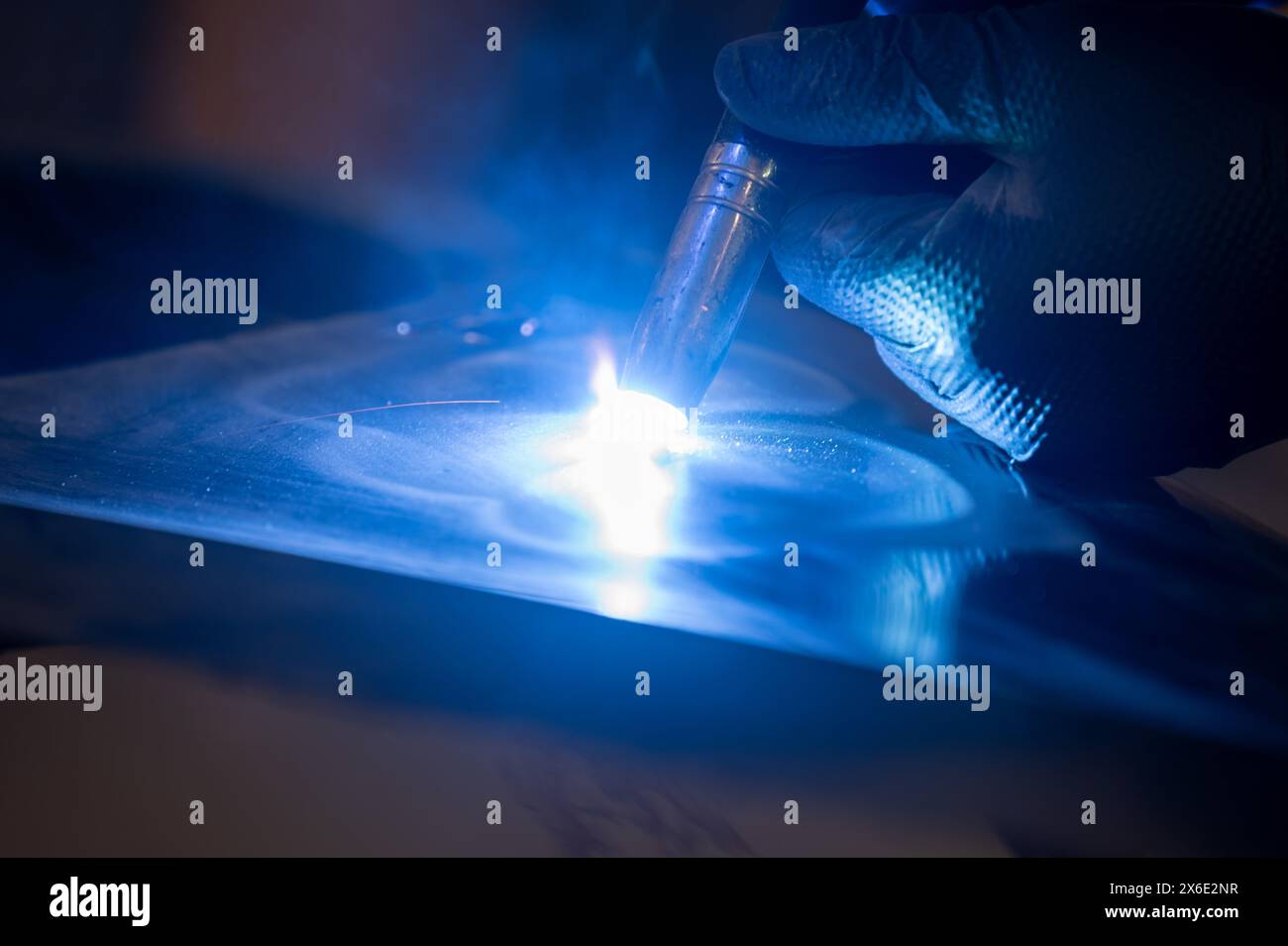 Close-up of tig welding process on metal surface with bright blue arc ...