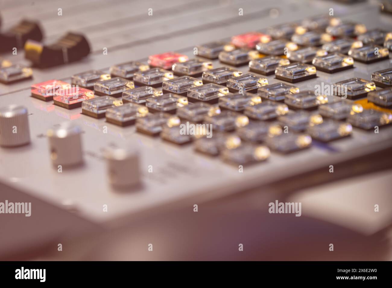 Close-up of professional audio mixer console with numerous knobs and ...