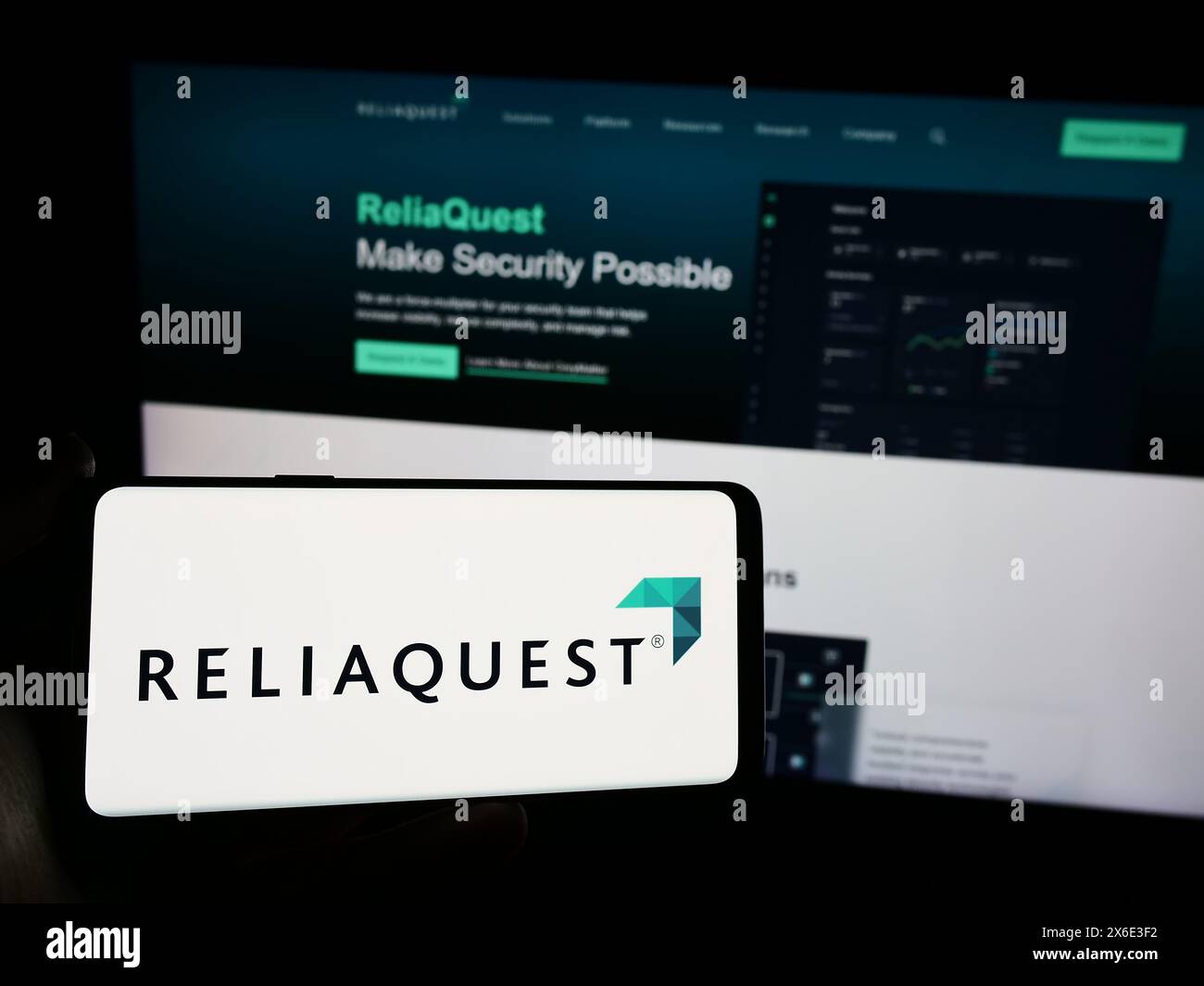 Person holding mobile phone with logo of American cybersecurity company ...