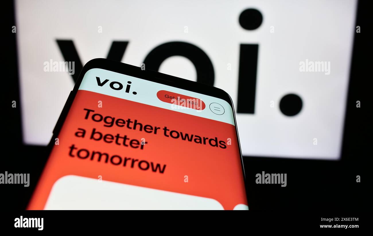 Mobile phone with website of Swedish electric scooter company Voi Technology AB in front of ...