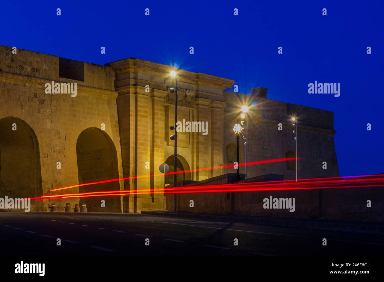 the Senglea main gate with car light trails taken at night Stock Photo ...