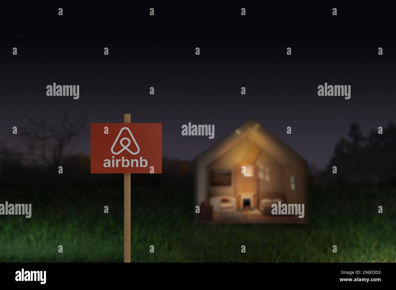 Airbnb sign next to a model house in the evening with lights on inside ...