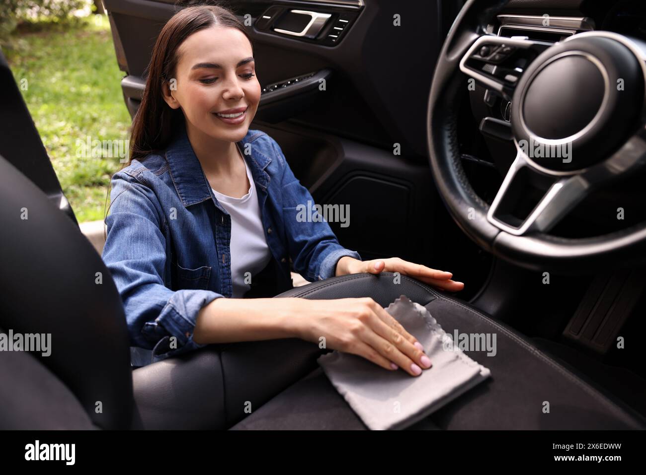 Woman wiping her modern car with rag Stock Photo - Alamy
