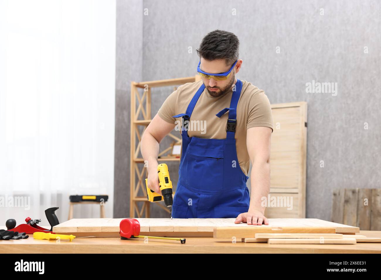 Young worker using drill hi-res stock photography and images - Alamy
