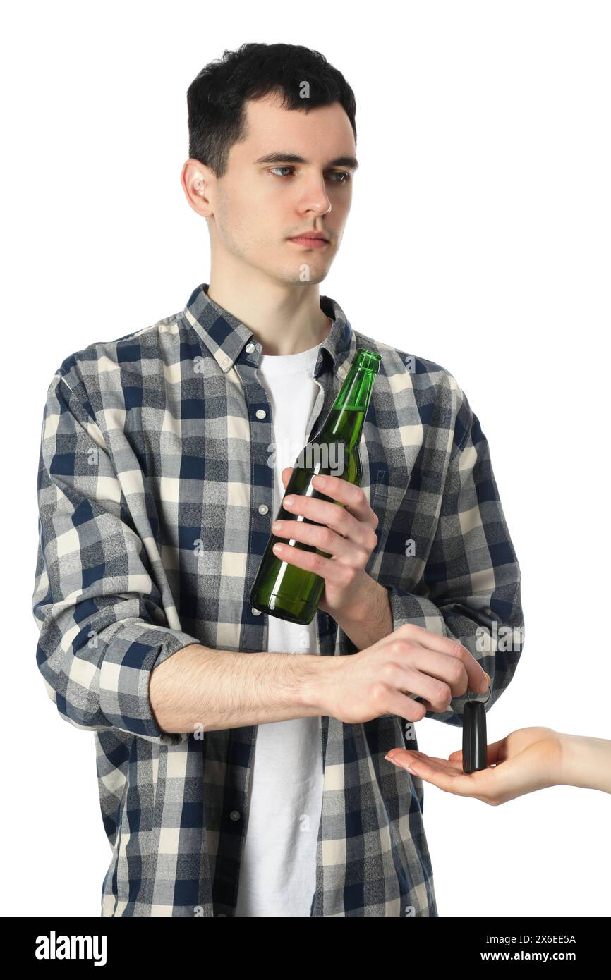 Man with bottle of beer giving car key to woman on white background ...