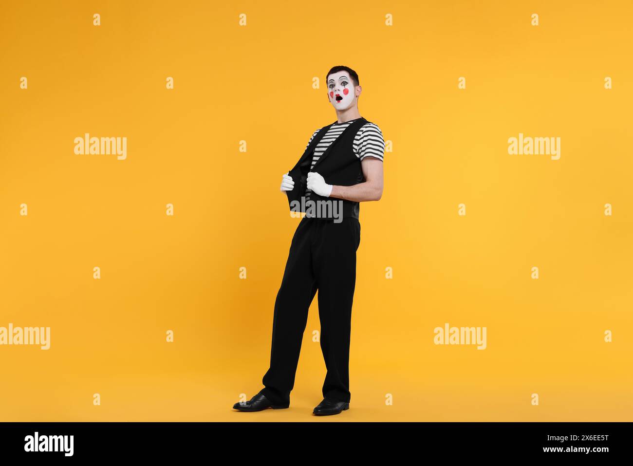 Mime artist making shocked face on orange background Stock Photo - Alamy