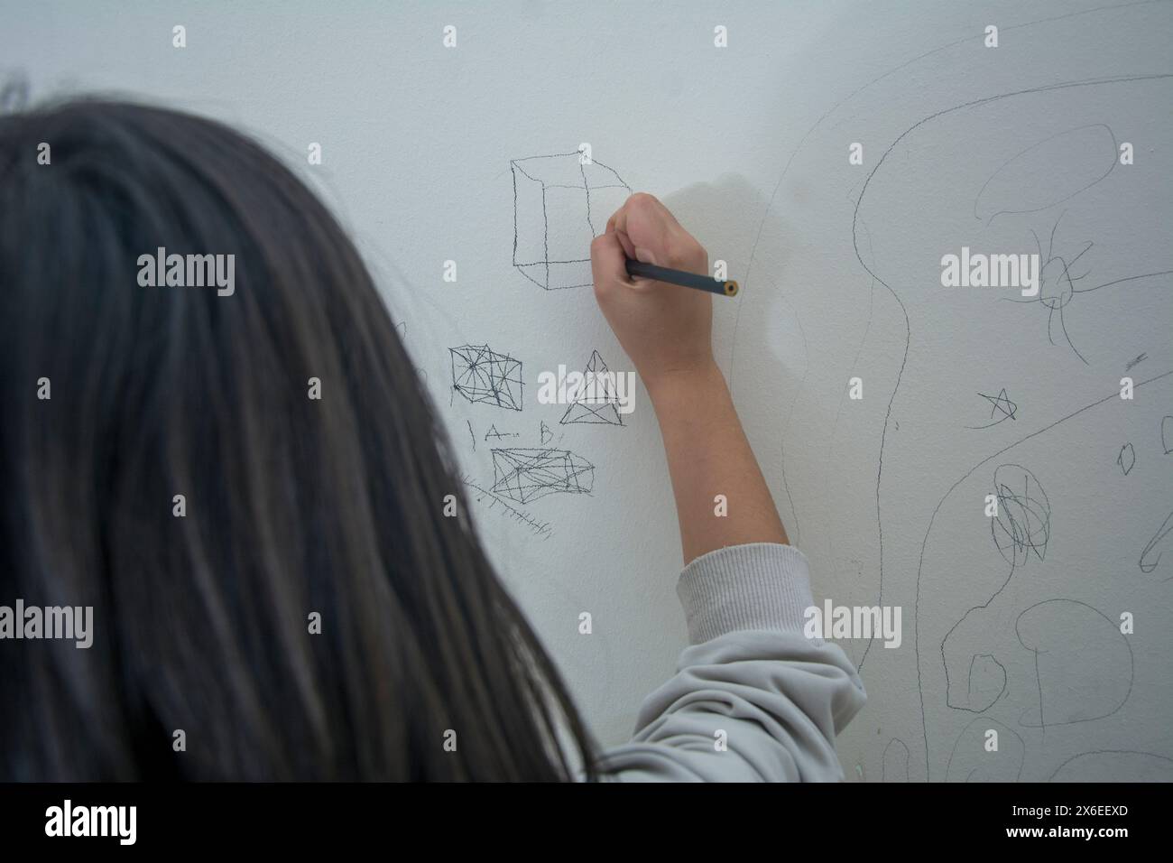 Unrecognizable little girl draws geometric shapes on the wall Stock ...
