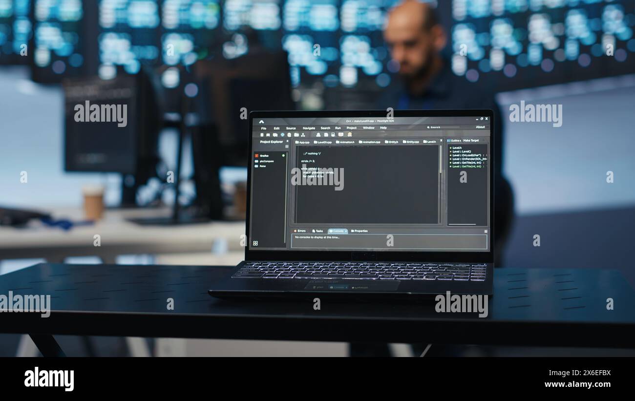 Focus on laptop used by technician in blurry background programming in ...