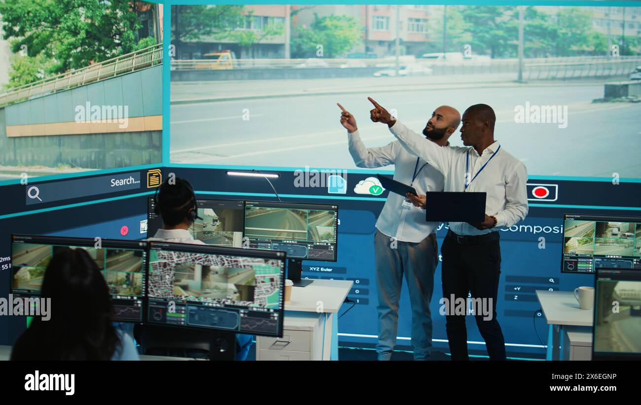 Diverse employees using CCTV surveillance system in monitoring traffic ...