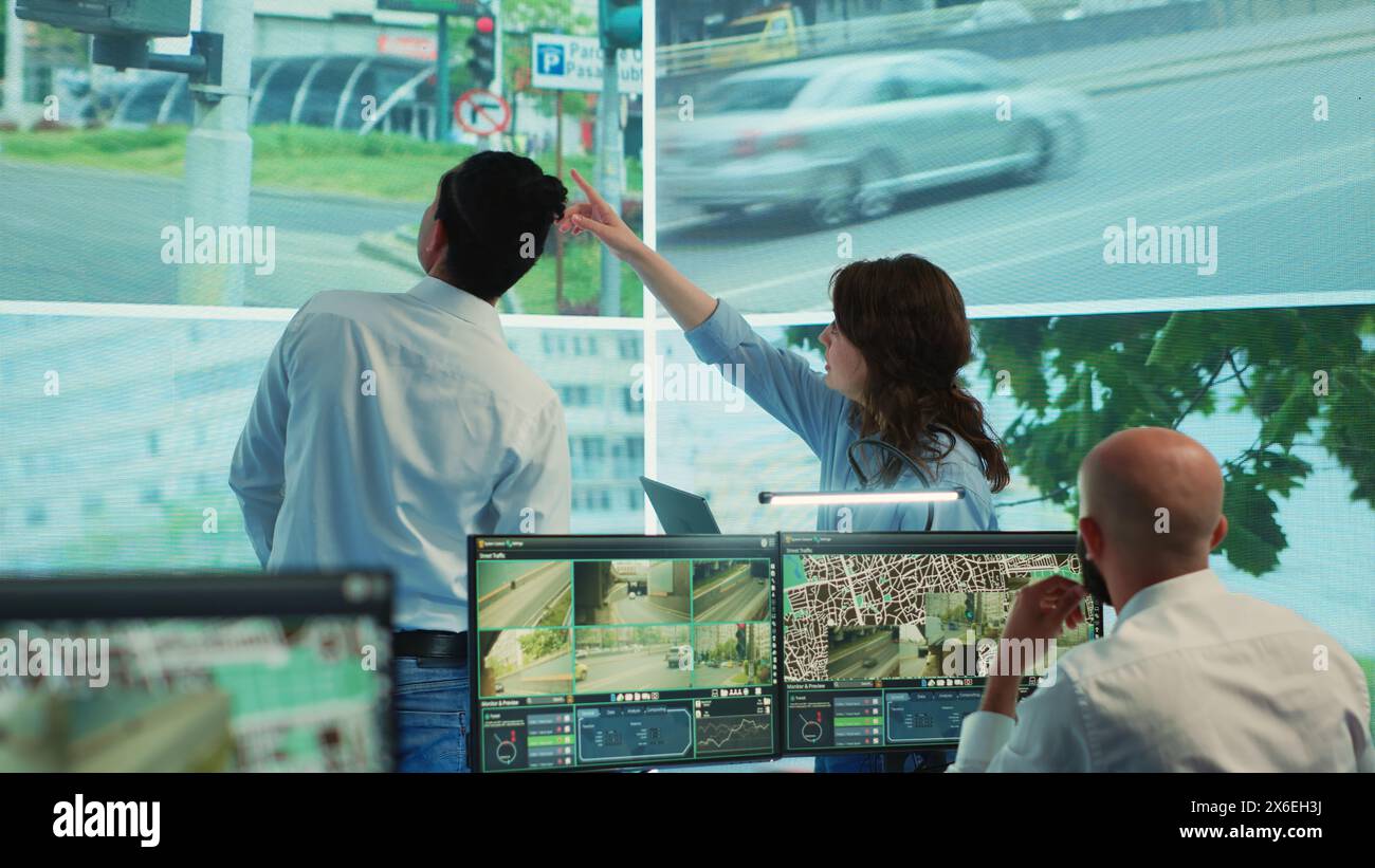 Diverse employees monitoring traffic via radar cameras at stop lights ...