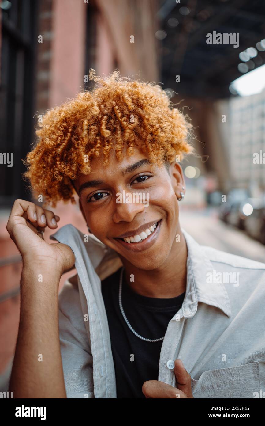 Happy young man with red hair and Jheri curl smiling for camera in cool ...