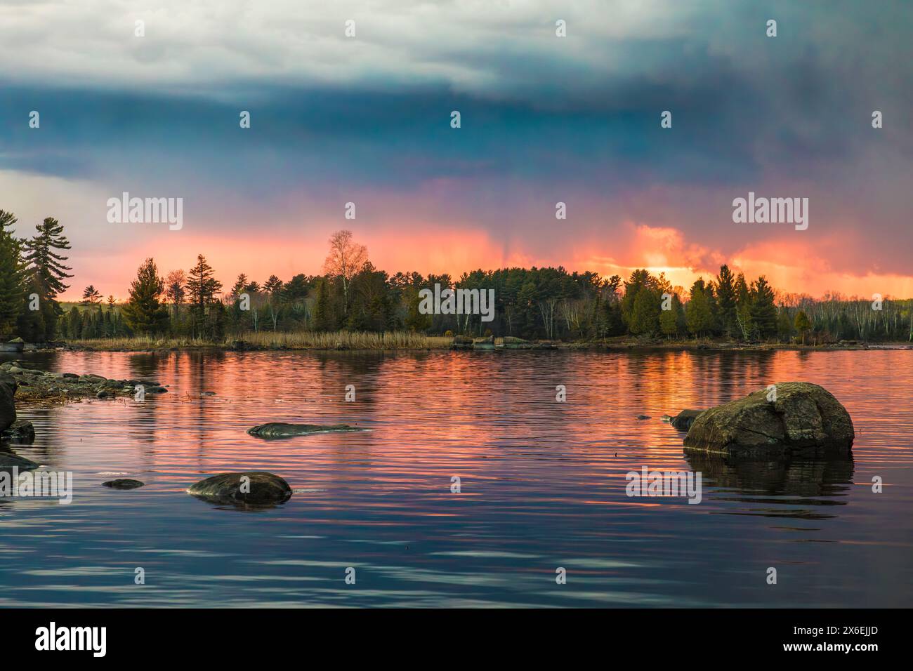 The sun sets over Boulder Lake near Duluth Minnesota as a storm front ...