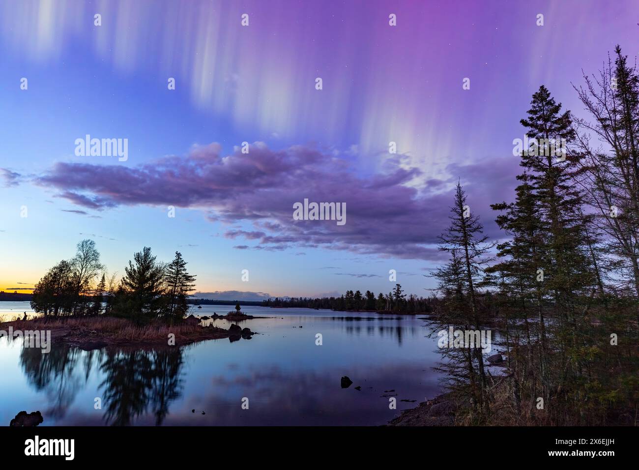 Northern lights erupt over a lake in Minnesota in a dark sky overhead ...