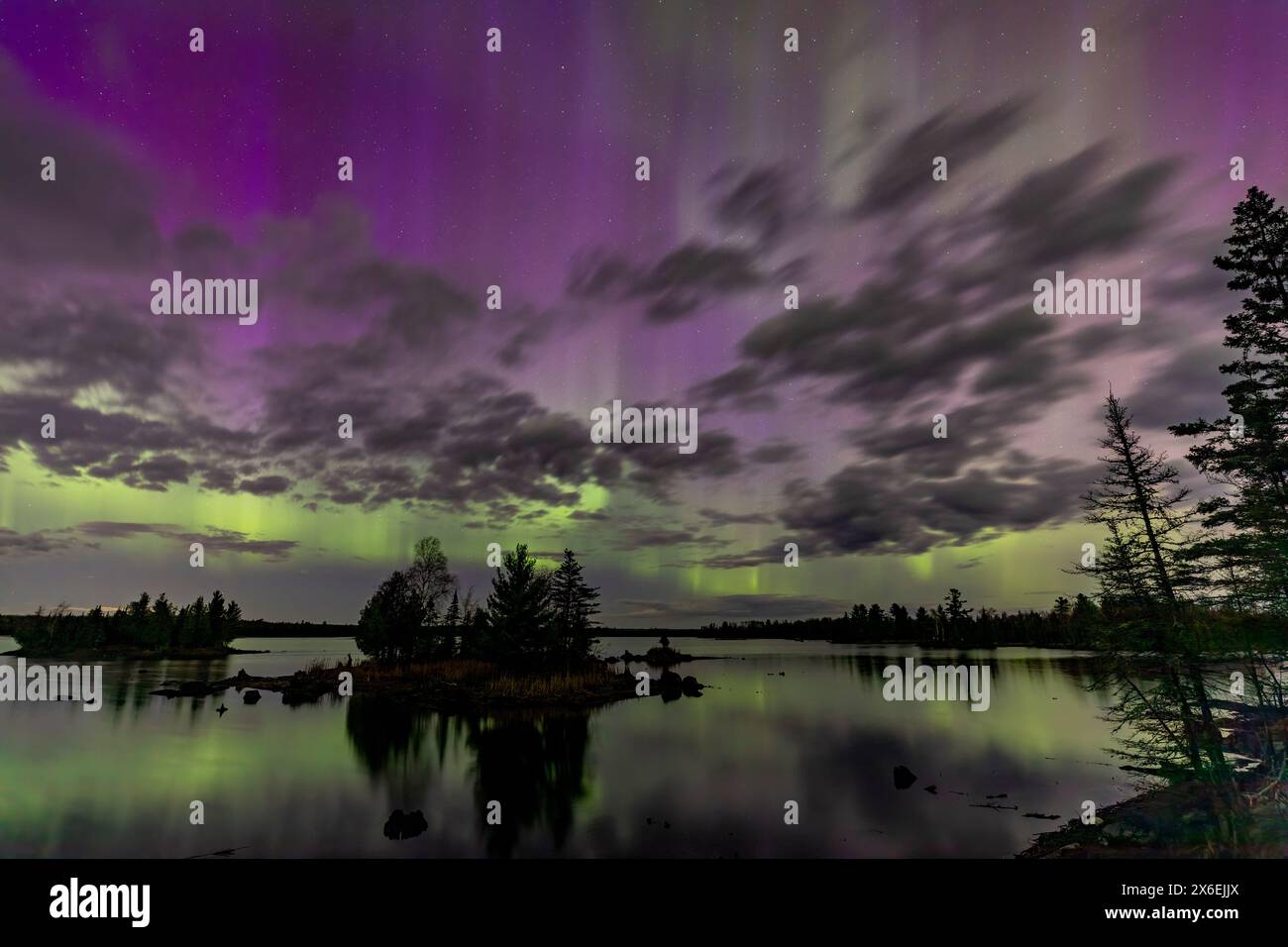 Northern lights erupt over a lake in Minnesota in a dark sky overhead ...