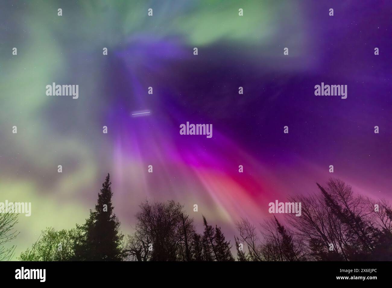 A satellite photo bombs a beautiful northern lights scene above Boulder Lake near Duluth ...